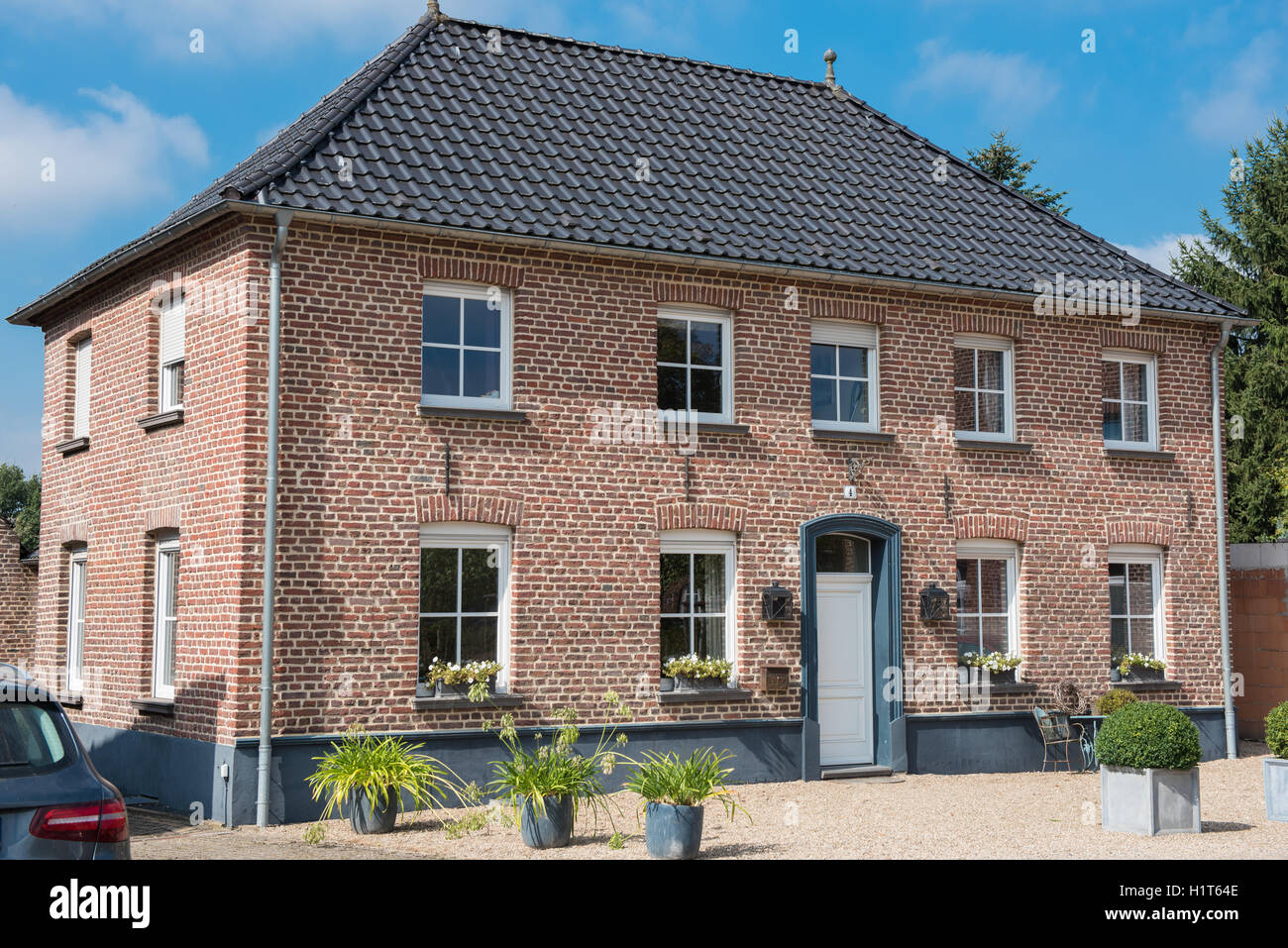 Maison en brique rouge avec des fenêtres blanches et blanc entrée ...