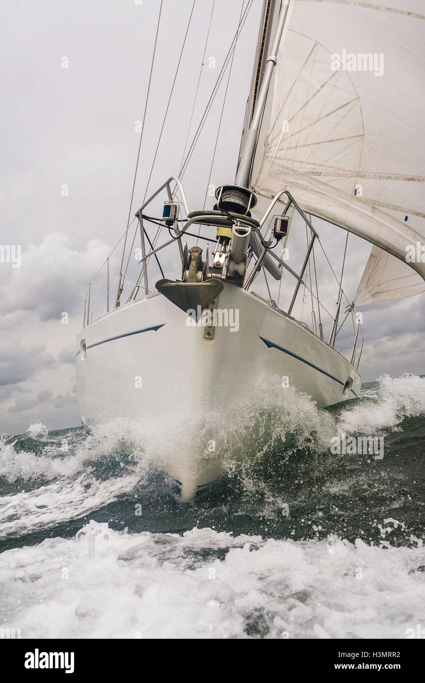 Close up sur la proue d'un bateau à voile ou yacht briser une vague sur ...