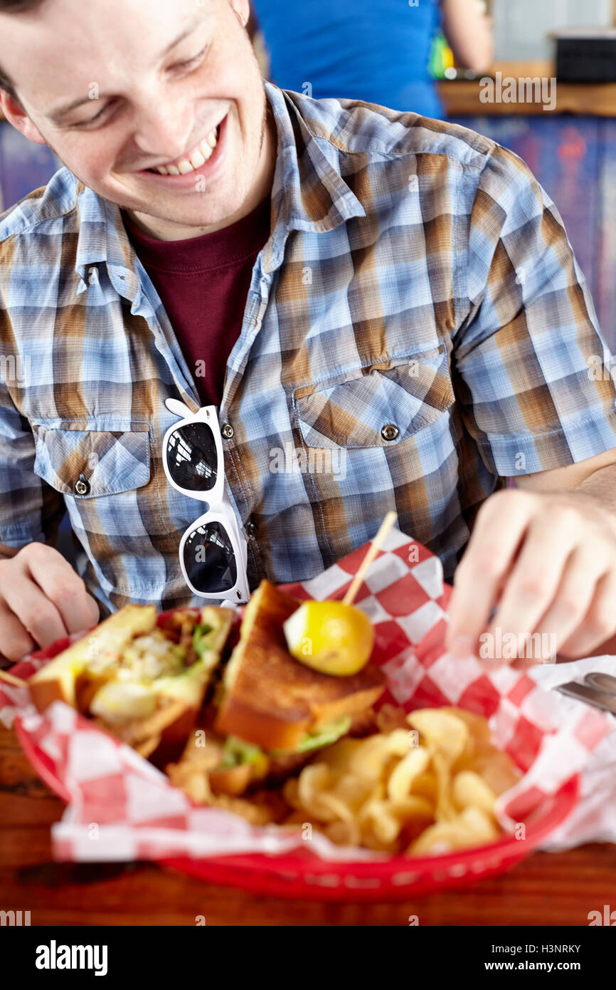 Young man eating fast food, smiling Photo Stock - Alamy