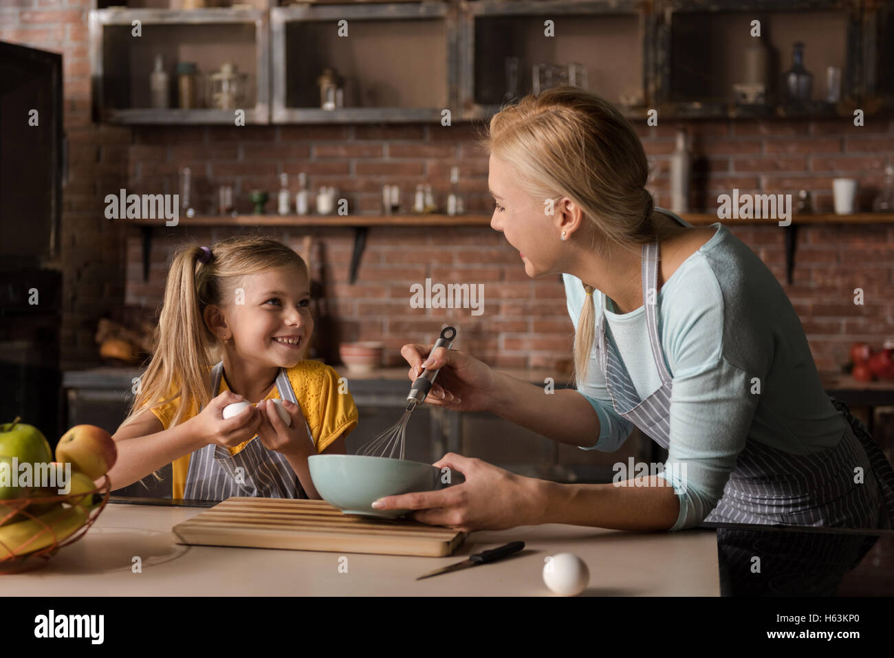 Happy little girl aider sa mère dans la cuisine Photo Stock - Alamy