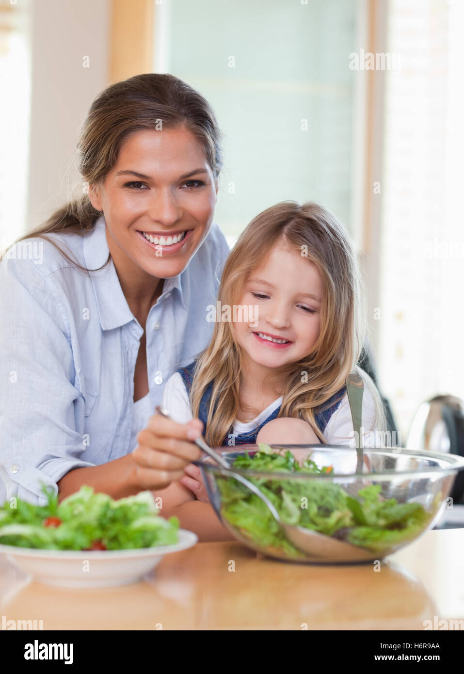 Portrait d'une jeune mère et sa fille préparer une salade dans sa ... Portrait d'une jeune mère et sa fille préparer une salade dans sa ...