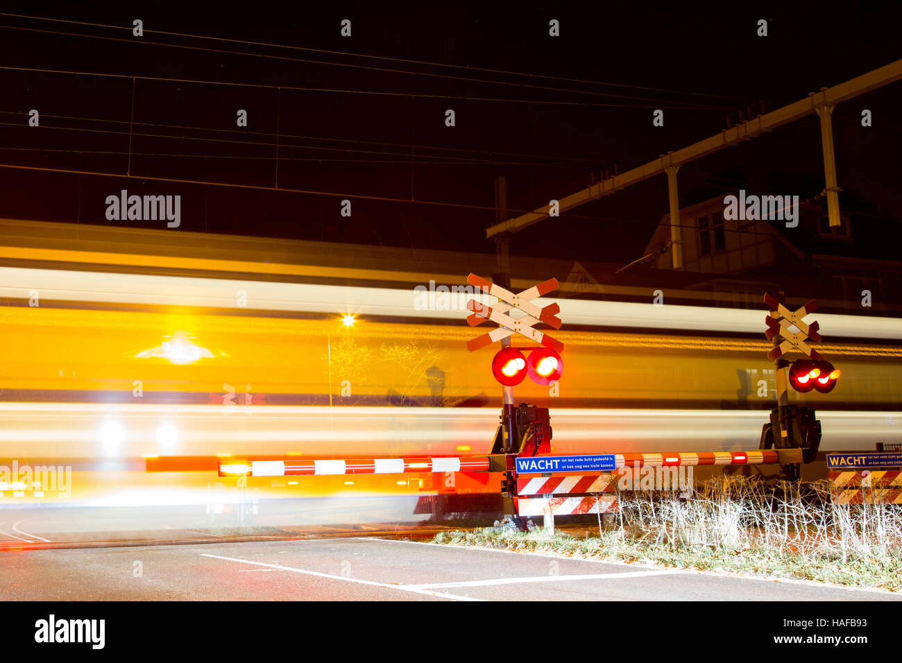 Barrière fermée à un passage à niveau avec train qui passe Photo Stock ...