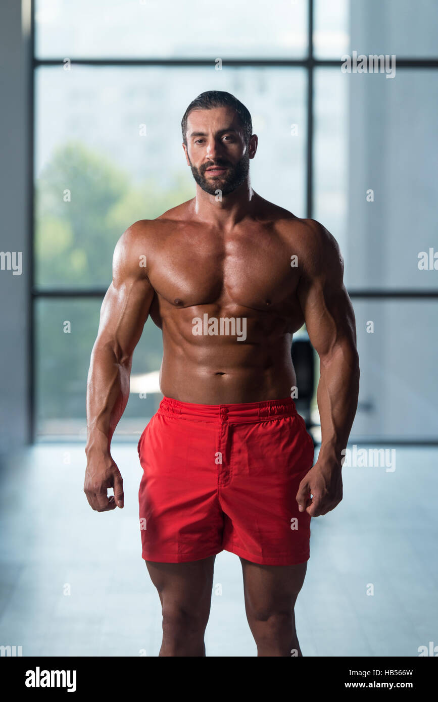 Jeune homme italien Soyons forts dans la salle de sport et Flexing ...