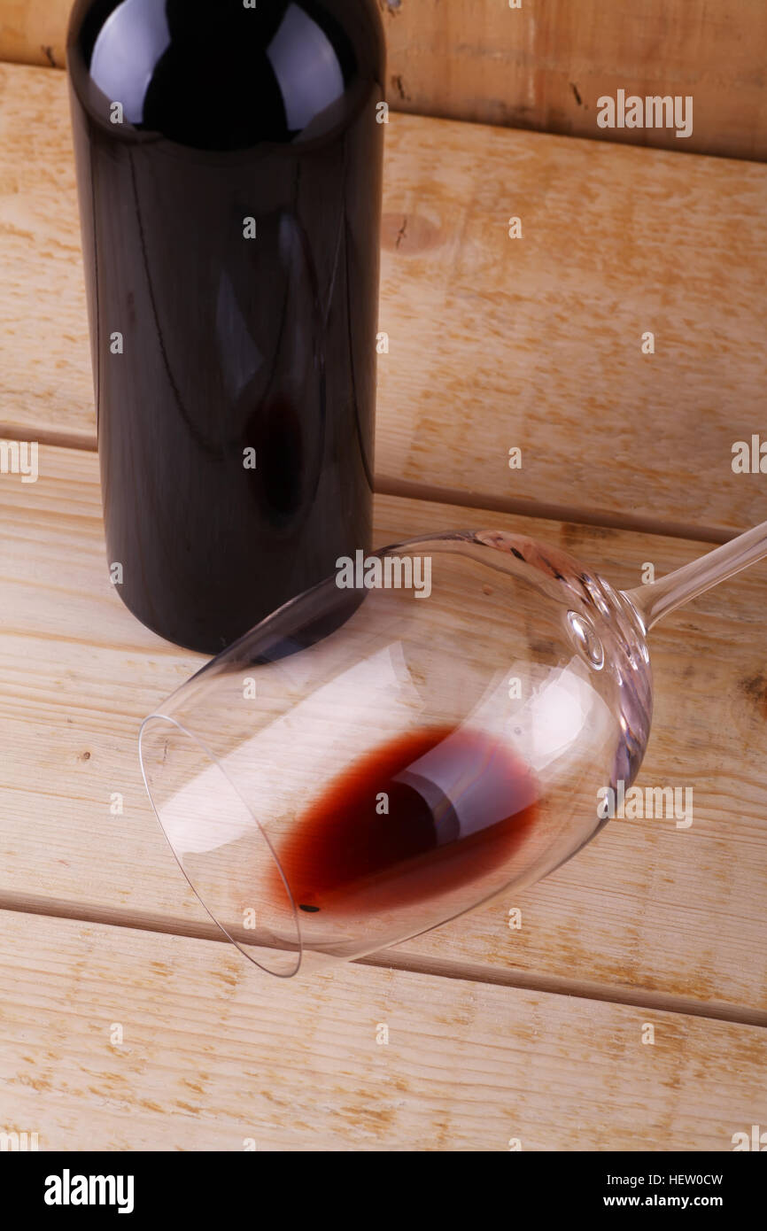 Verre et bouteille de vin rouge vide sur un fond de bois texturé Photo ...