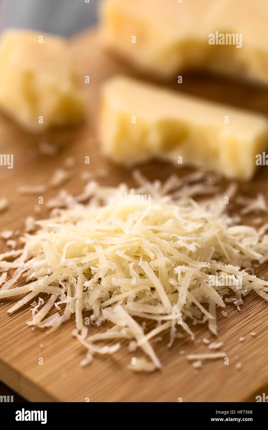 De parmesan fraîchement râpé-comme du fromage dur sur planche de bois ...