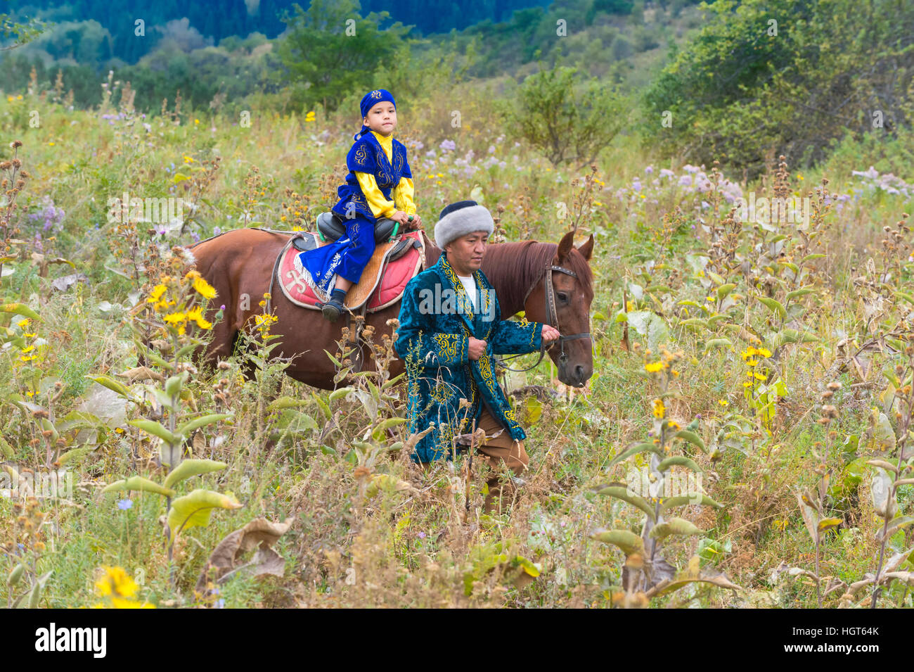 Balades autour de l'homme kazakh avec son fils sur un cheval après la ...
