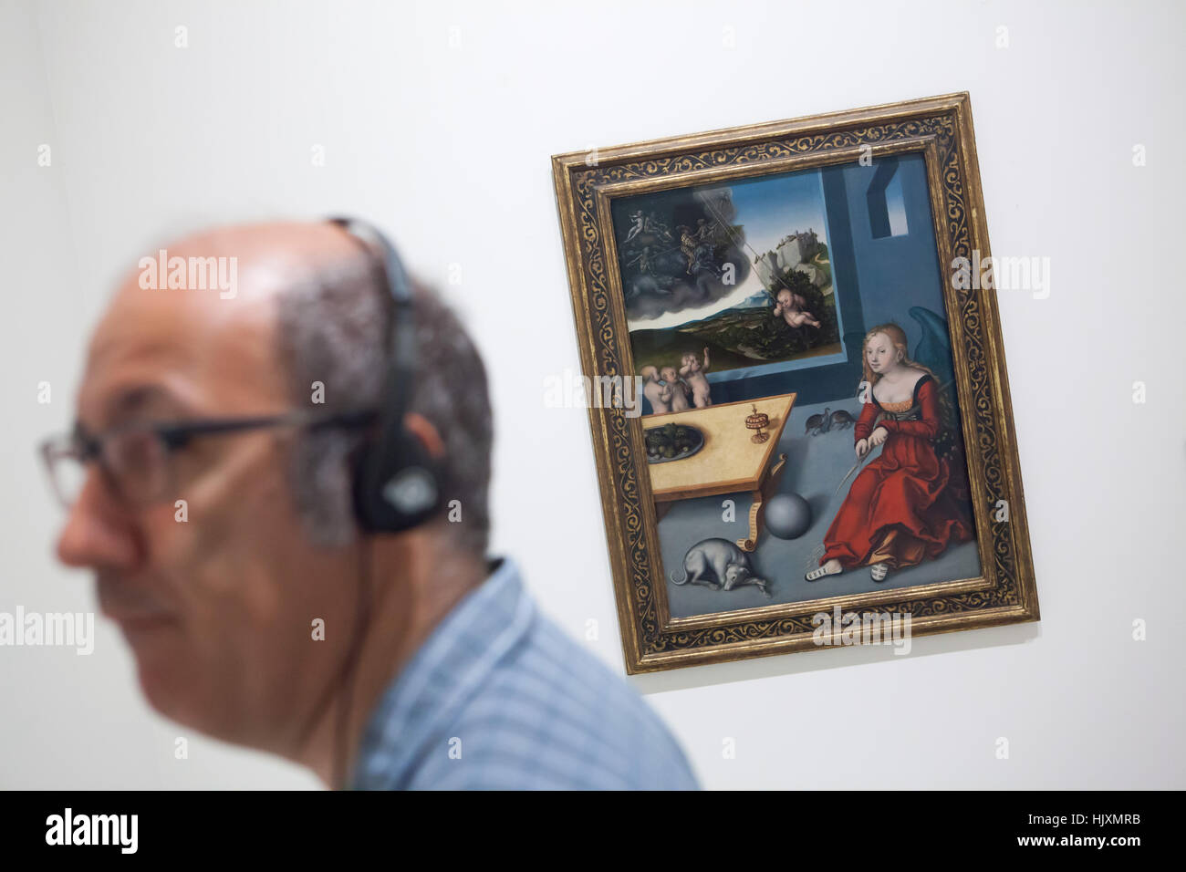 Visiteur utilise un guide audio à l'avant de la mélancolie (1532) Peinture par peintre allemand ...