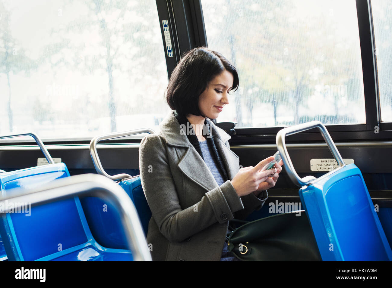 Une jeune femme assise dans un train et en regardant un téléphone ...