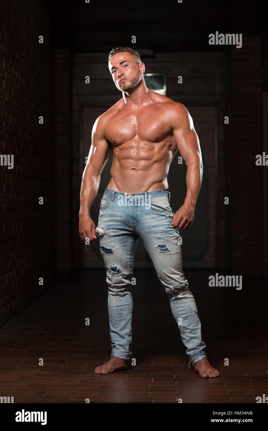 Portrait d'un jeune homme en bonne forme physique en jeans montrant son ...