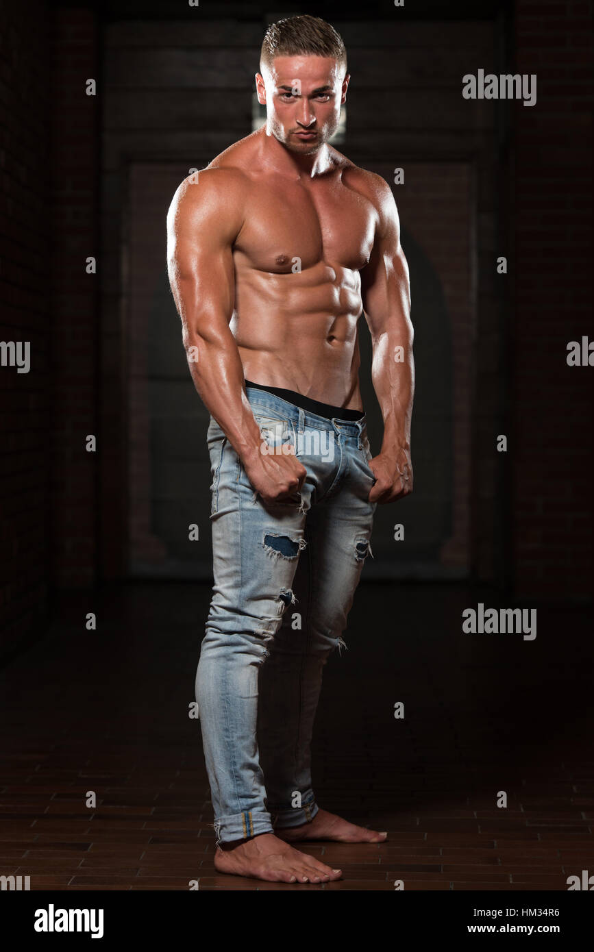 Portrait d'un jeune homme en bonne forme physique en jeans montrant son ...