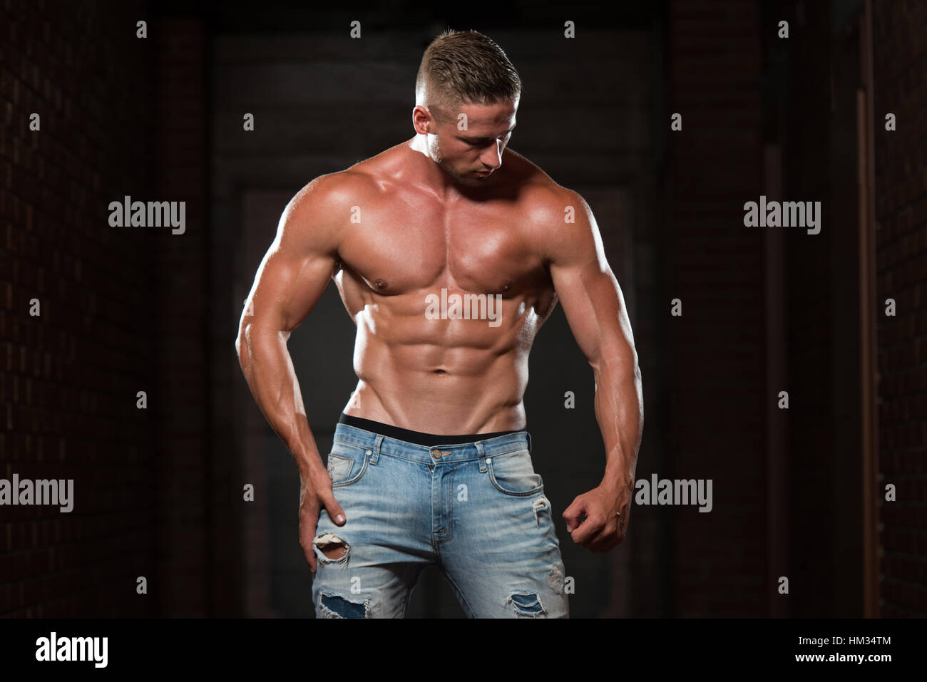 Jeune homme sain en jeans Soyons forts dans la salle de sport et ...