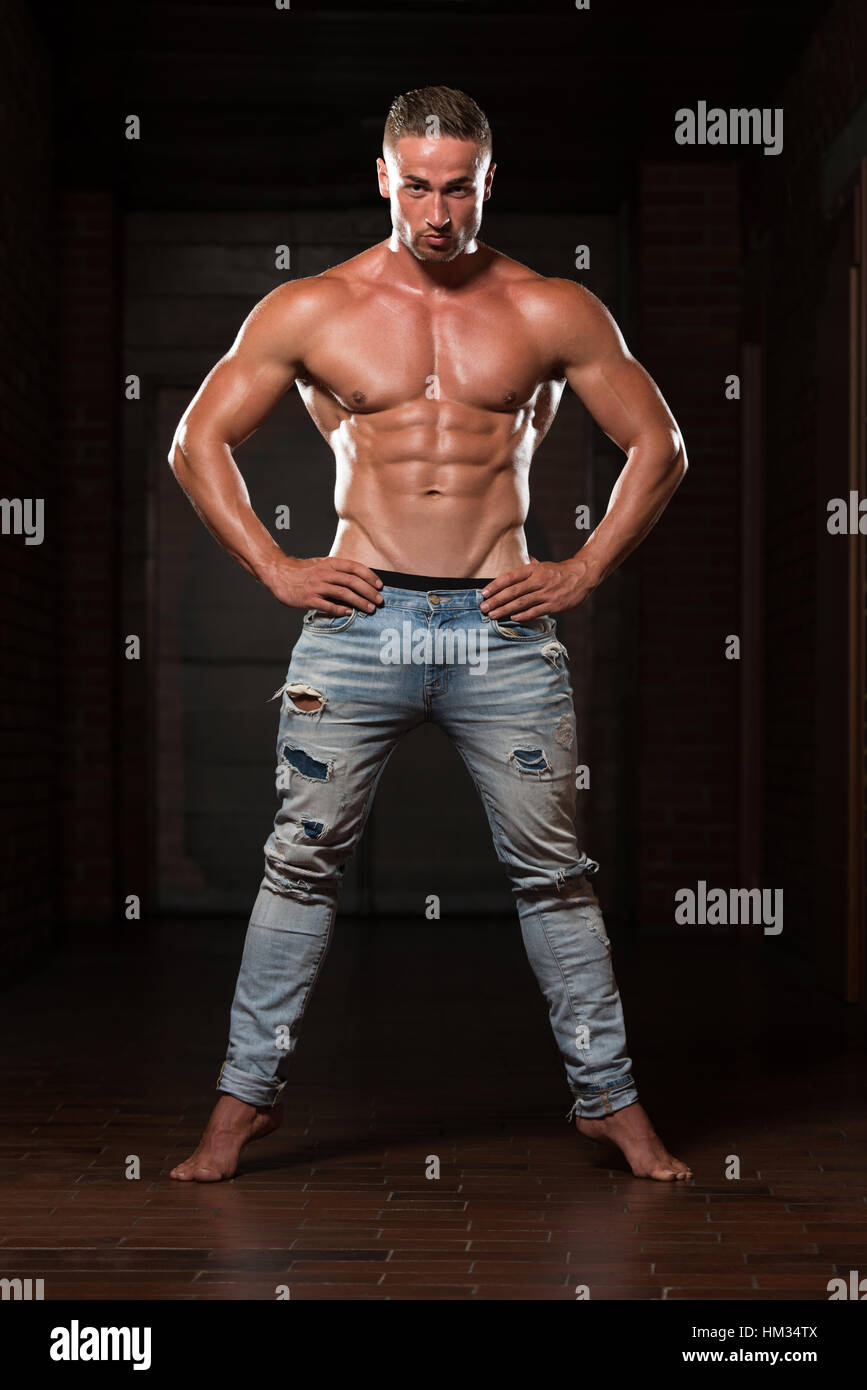 Portrait d'un jeune homme en bonne forme physique en jeans montrant son ...
