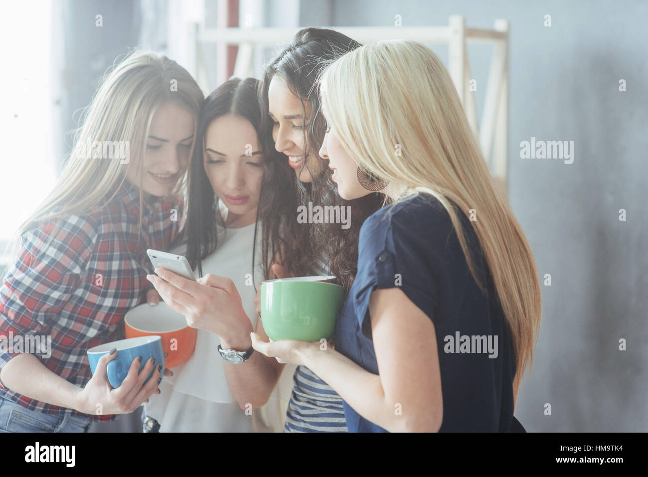 Beau groupe de jeunes bénéficiant de la conversation et de boire du ...