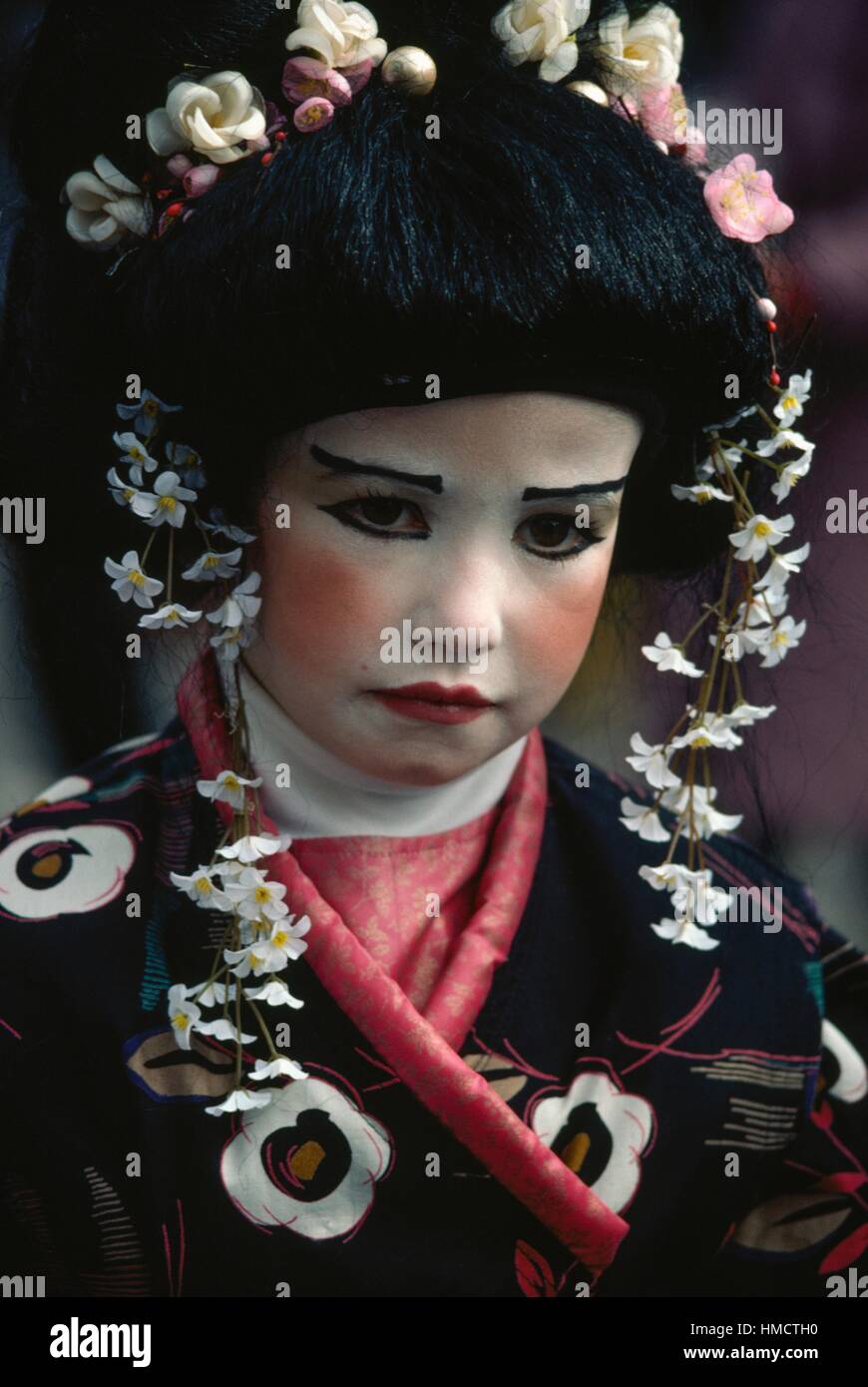 Enfant avec visage peint habillé comme une geisha, carnaval de Binche ...