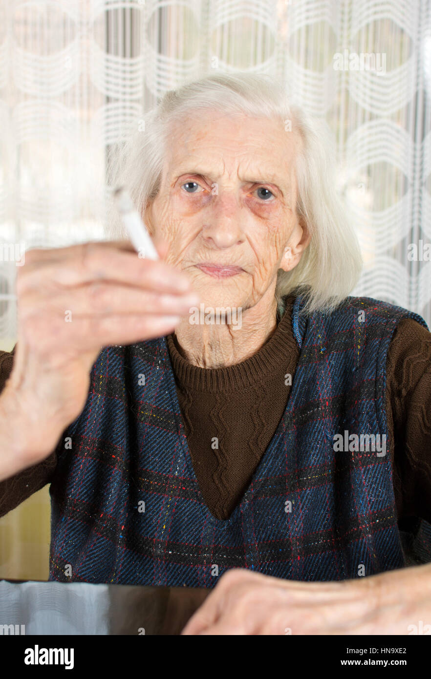 Vieille grand-mère de fumer la cigarette à la maison Photo Stock - Alamy