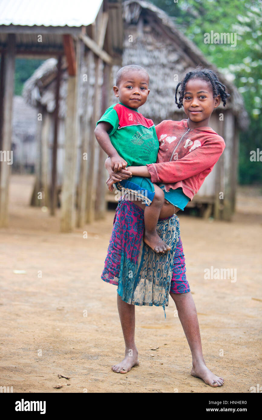 Smiling portrait d'une petite fille malgache tenant son frère dans ses ...