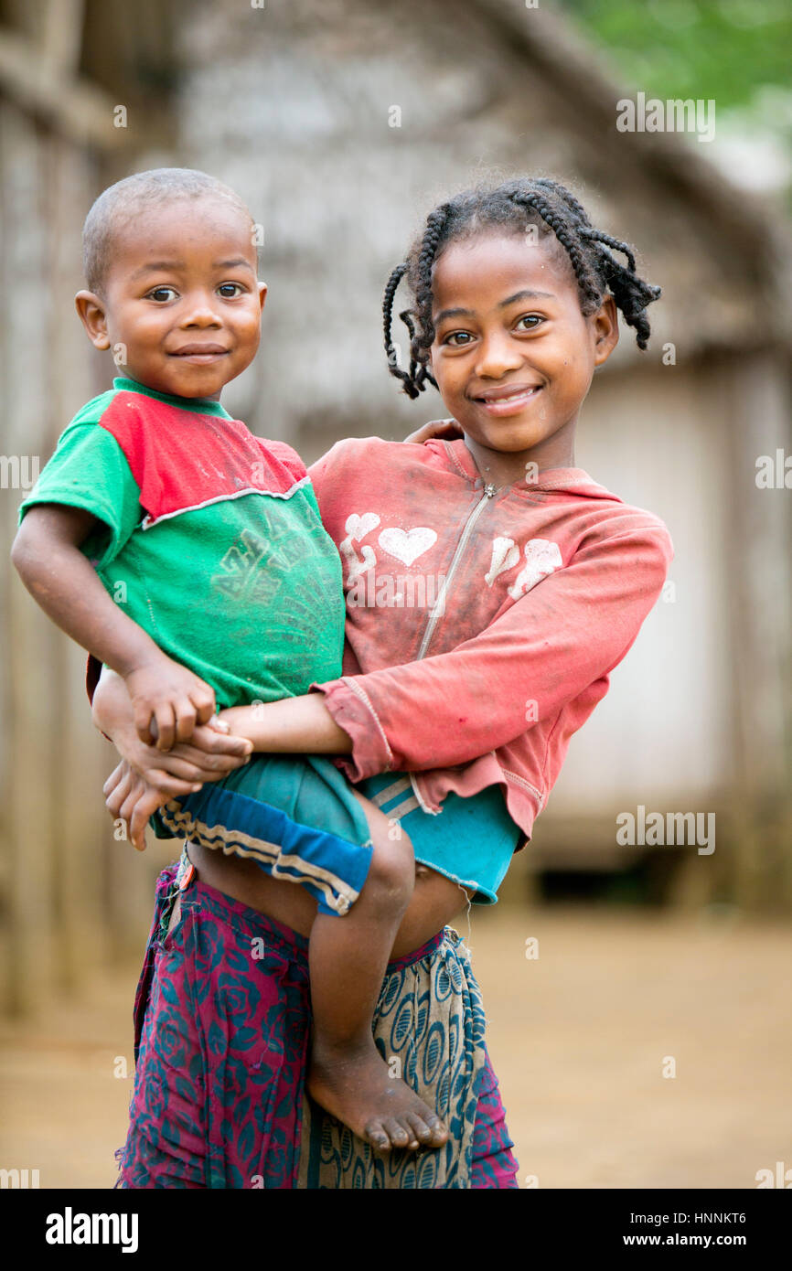 Smiling portrait d'une petite fille malgache tenant son frère dans ses ...