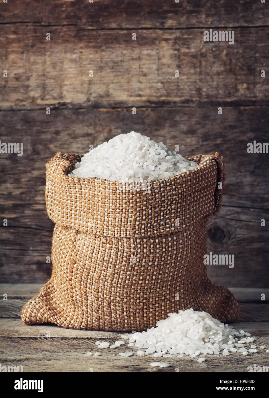Riz blanc en sac de toile avec des tas de grains de riz sur fond de ...