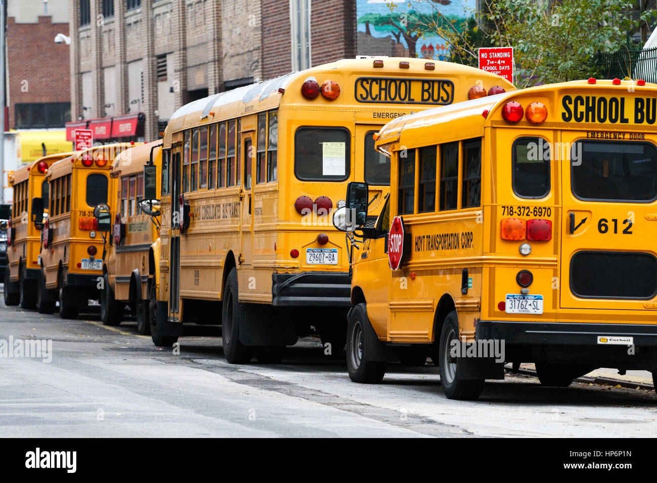 Une ligne de bus scolaire jaune garée dans une petite rue à Manhattan ...
