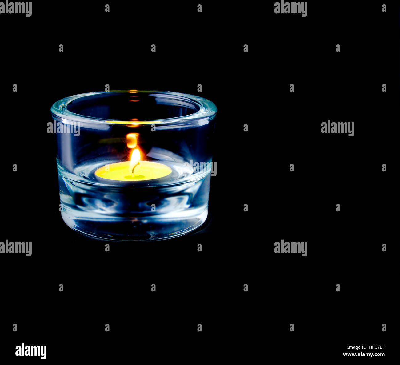 Green,cierge allumé en verre sur fond noir.Espace pour texte.Tealight ...