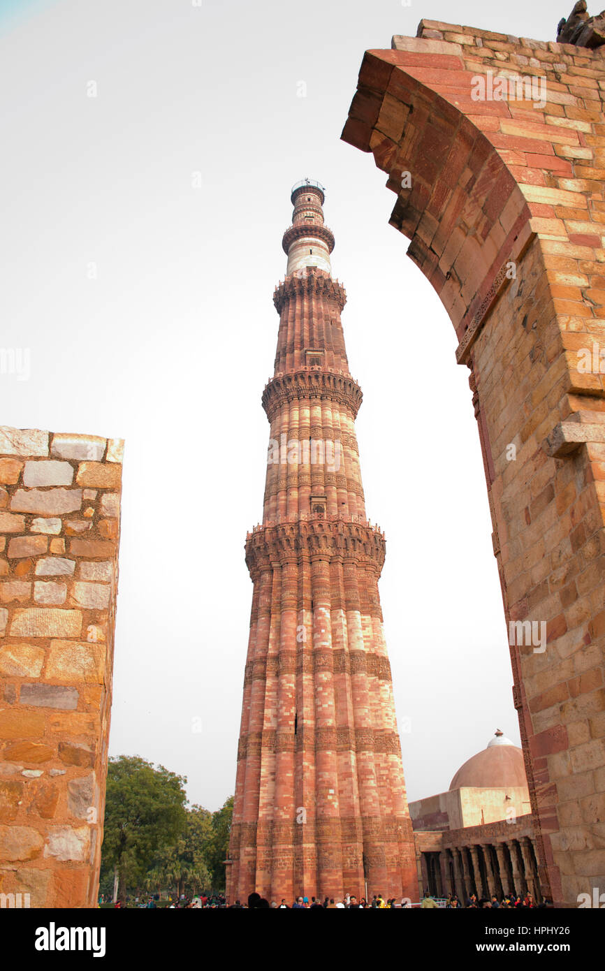 Le Qutub Minar minaret, vue à travers une arche, dans le complexe Qûtb ...