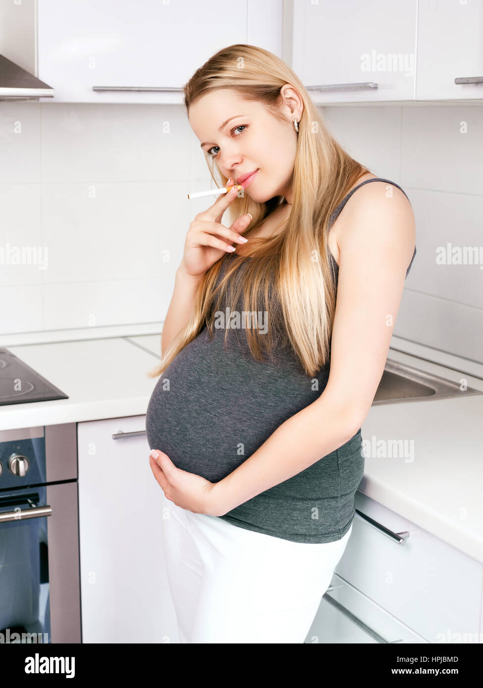 Femme enceinte fumer des cigarettes à la maison Photo Stock - Alamy