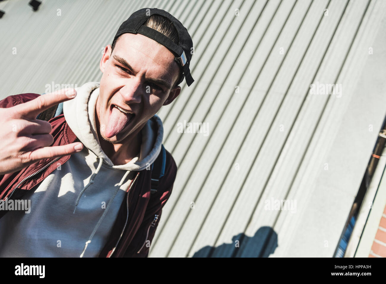 Portrait de jeune homme agressif et gestes sticking out tongue Photo ...