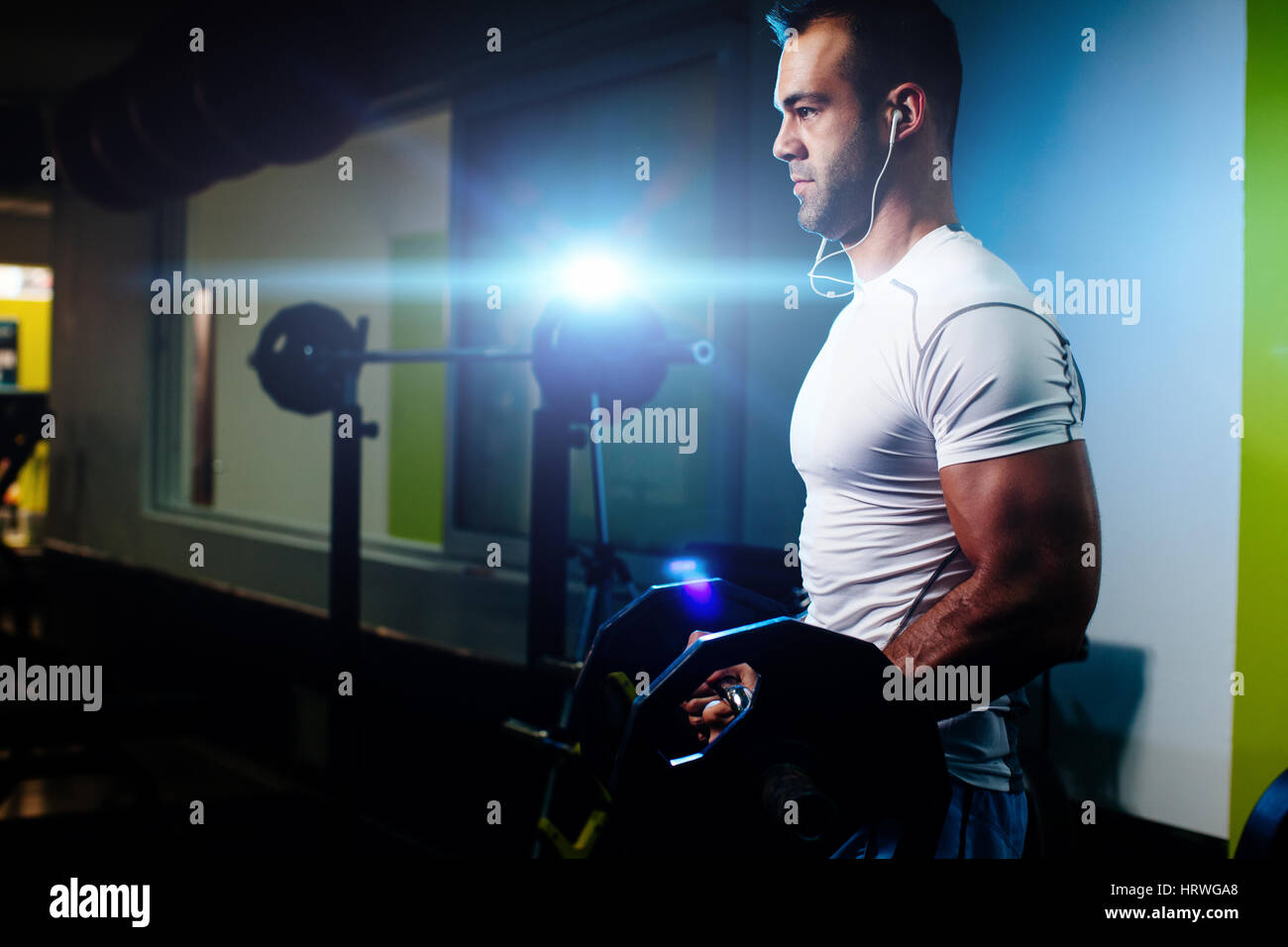 Pompage bodybuilder up hands et écouter la musique dans une salle de ...