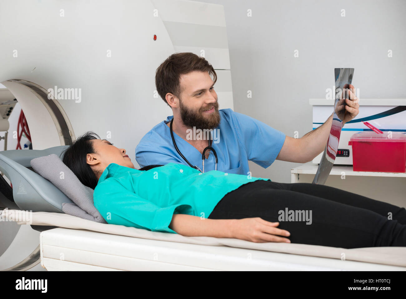 Jeune homme radiologue montrant rapport radiologique à female patient ...