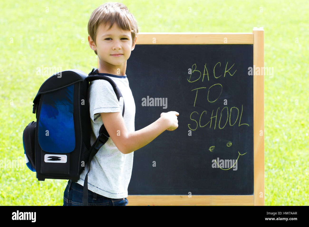 Petit écolier de l'écriture sur tableau noir. L'éducation, concept ...