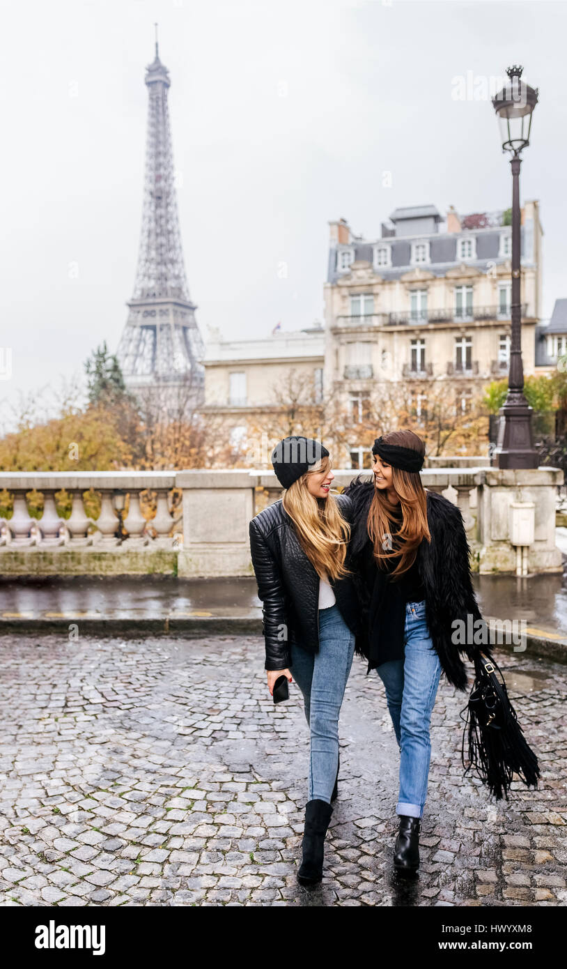 France, Paris, deux meilleurs amis marchant dans la rue avec la Tour ...