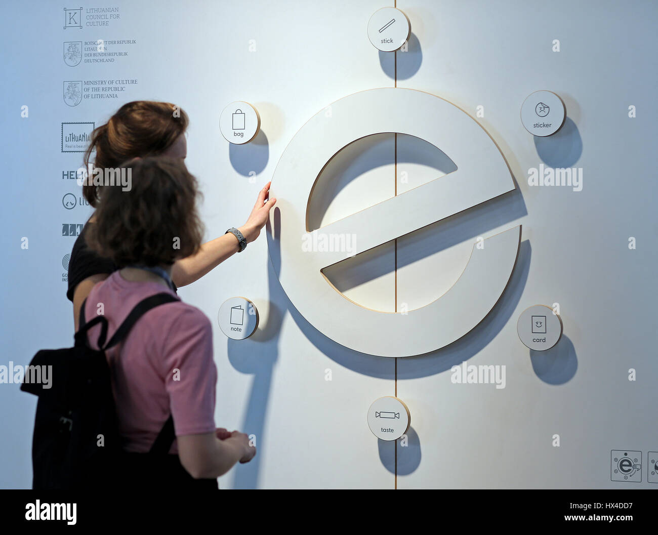 Deux femmes se tiennent devant un 'e' conçu par un concepteur graphique ...