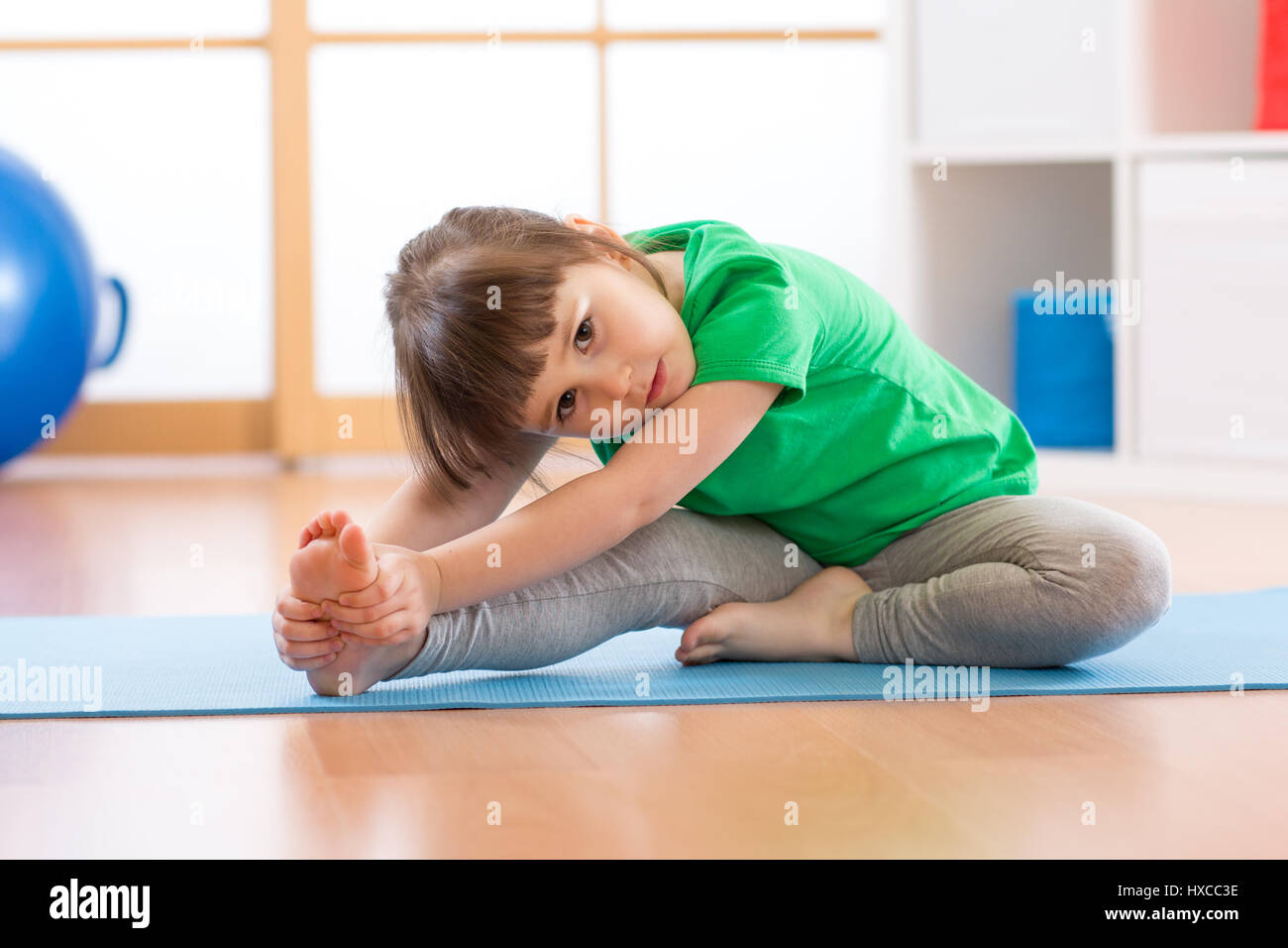 Cute little girl stretching in gym Photo Stock - Alamy