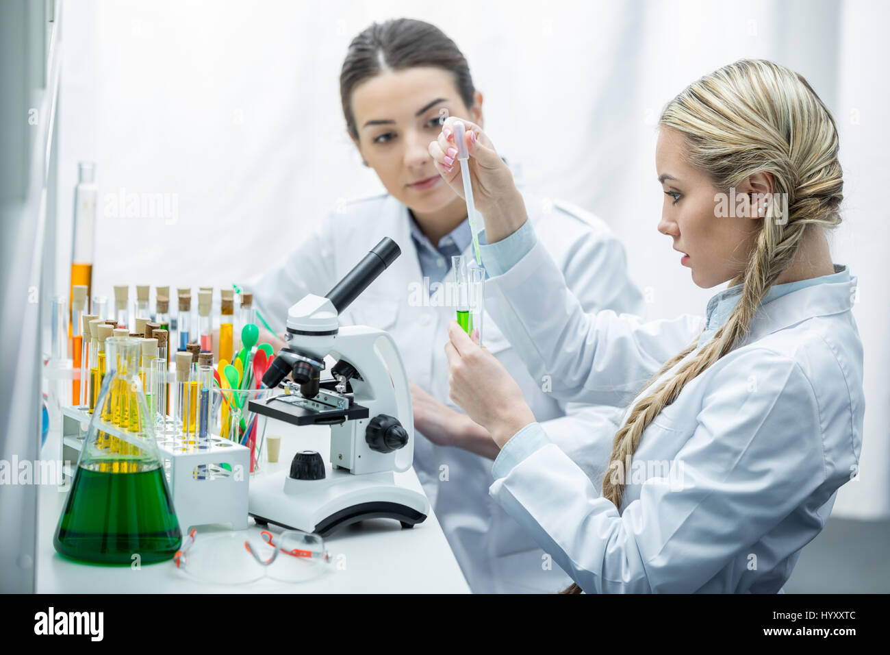 Les jeunes femmes scientifiques dans l'expérience de laboratoire ...
