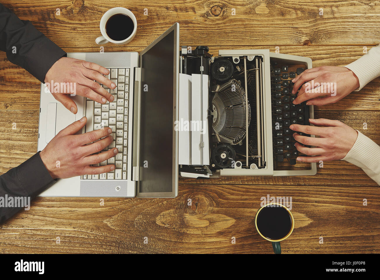 Femme écrit sur une machine à écrire et un homme travaillant sur un ...