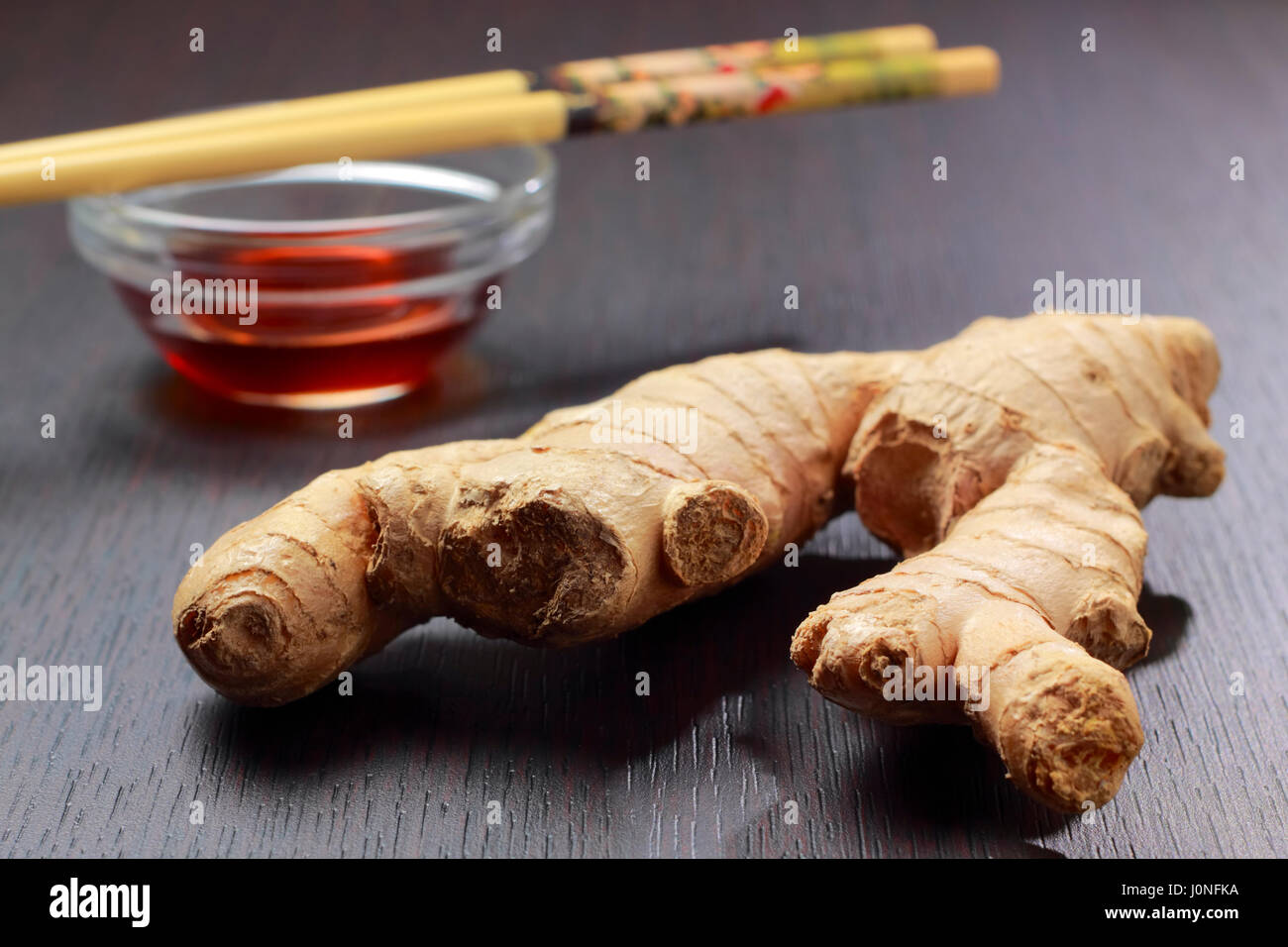 La racine de gingembre (rhizome) lying on the board avec une cuvette et ...