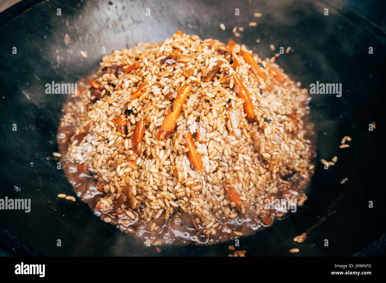La cuisson dans la marmite. plov Le riz, la viande, les oignons et les ...