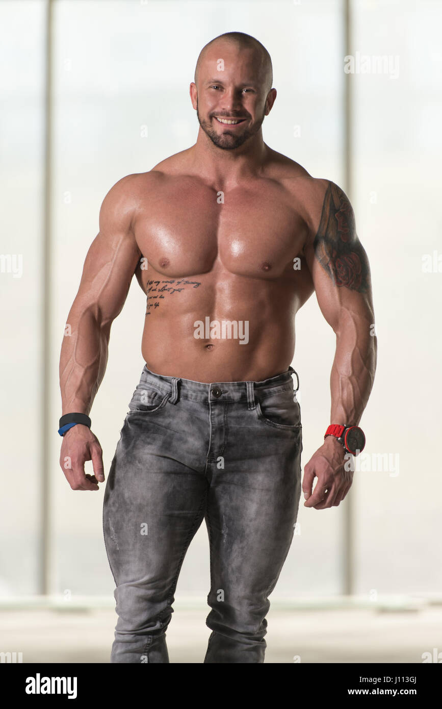 Portrait d'un jeune homme en bonne forme physique montrant son tatouage ...