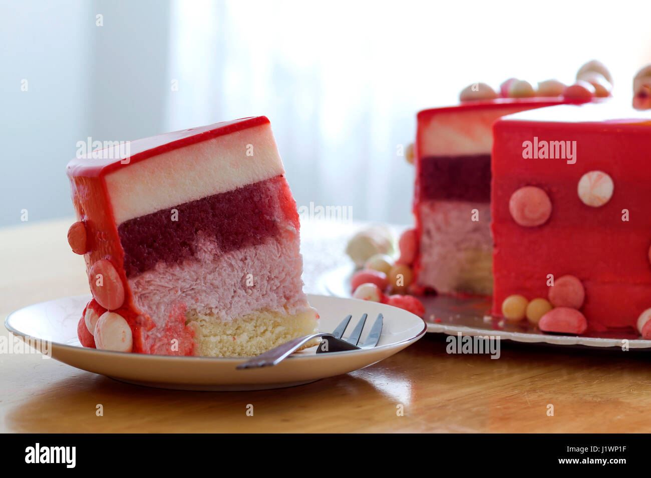 Gâteau d'anniversaire rouge fait maison avec air baloons. Une tranche ...