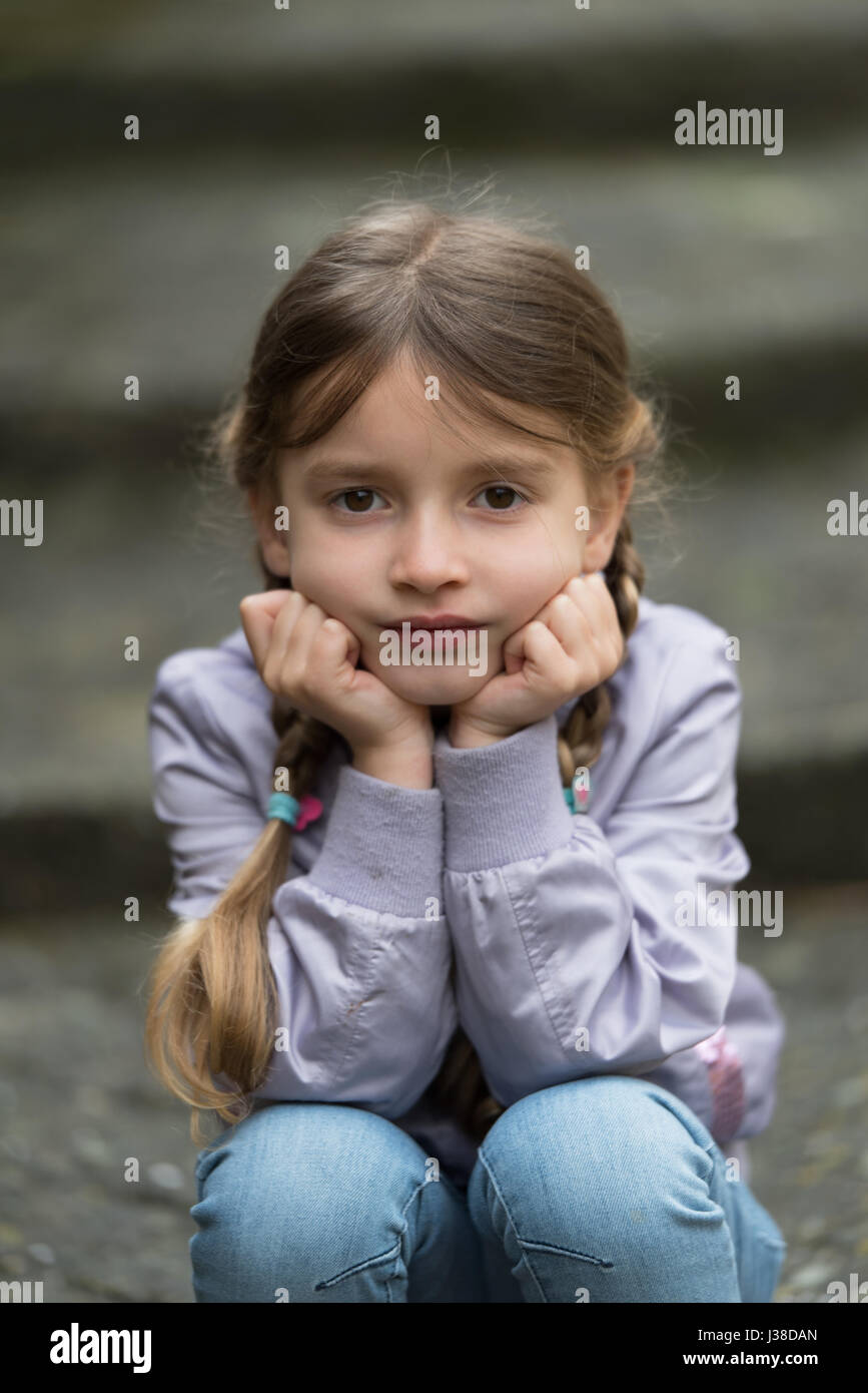 Petite fille assise sur les escaliers sur jour de pluie Photo Stock - Alamy