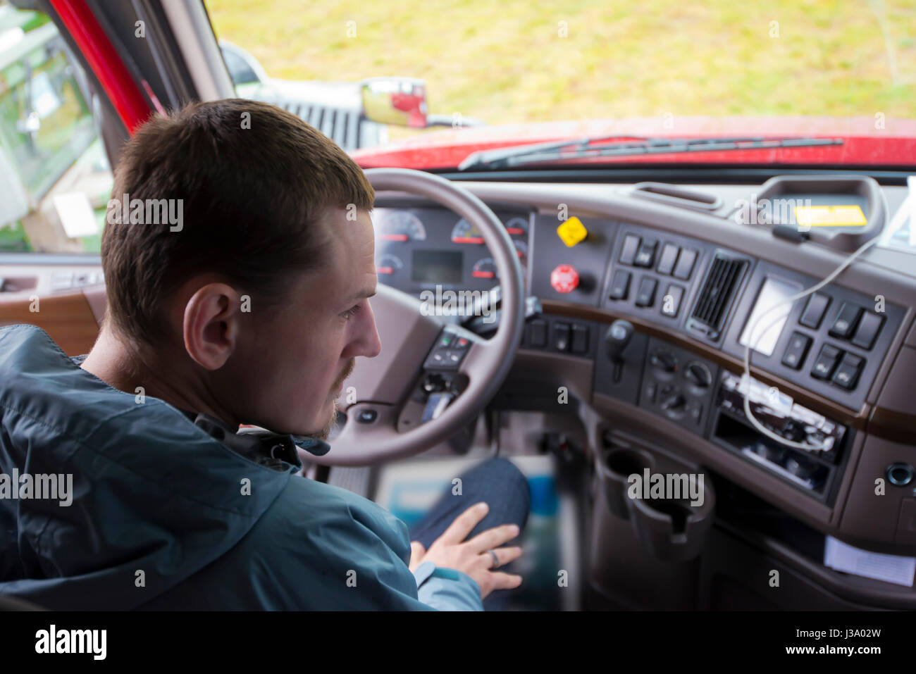 Le conducteur du chariot assis dans la cabine de confort moderne et de ...
