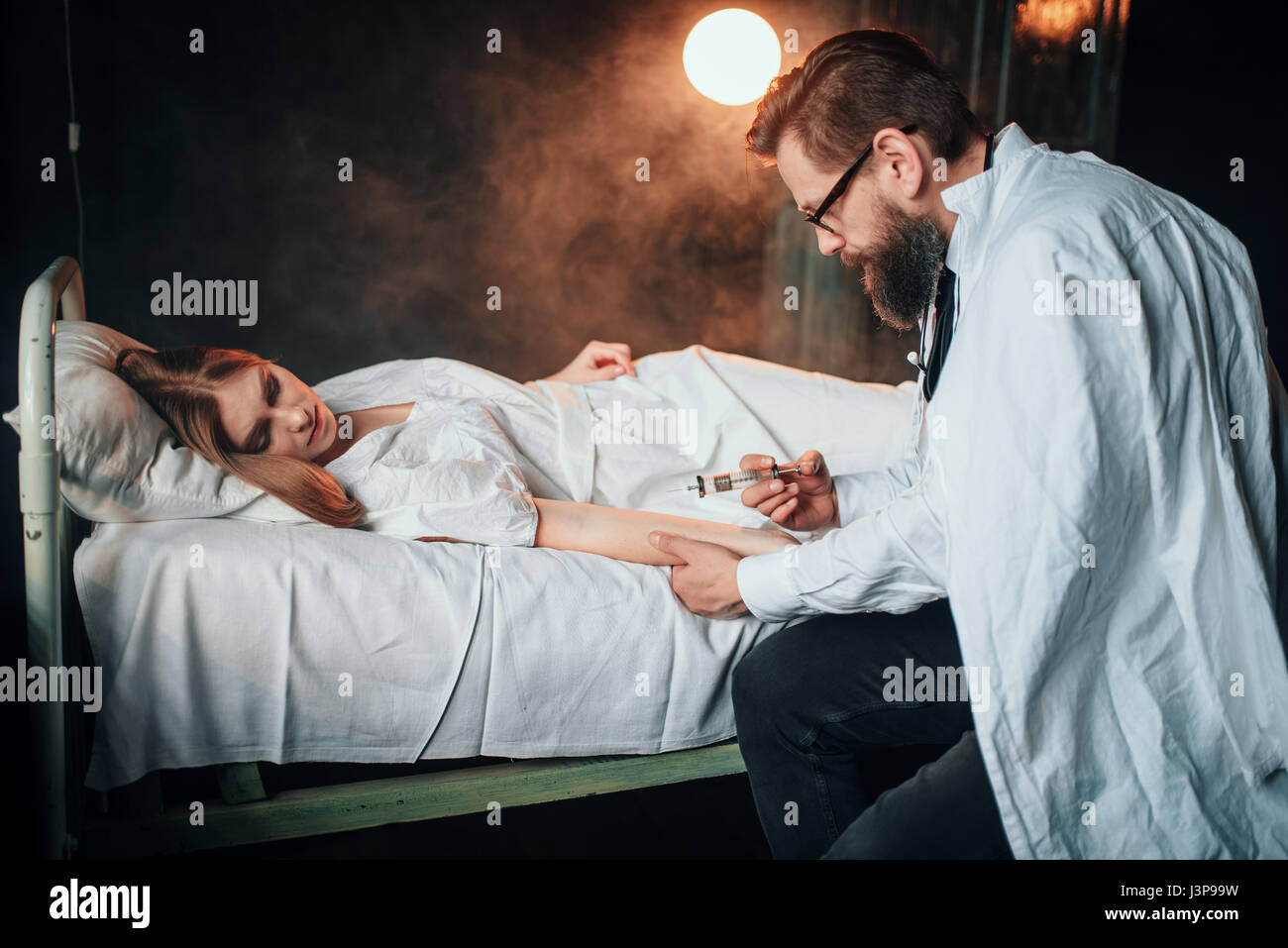 Médecin homme rend l'injection seringue de femme malade dans lit d ...