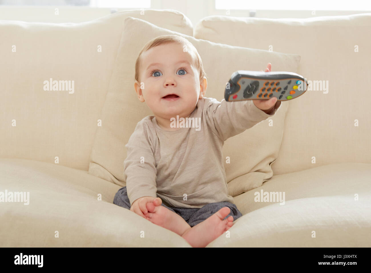 Baby with remote control Banque de photographies et d’images à haute ...