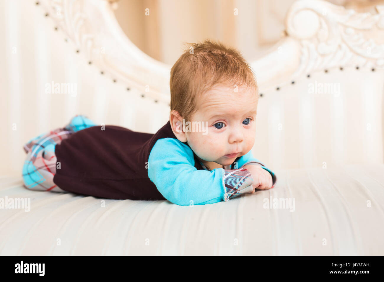 Adorable bébé garçon avec les cheveux rouges et les yeux bleus. Le ...