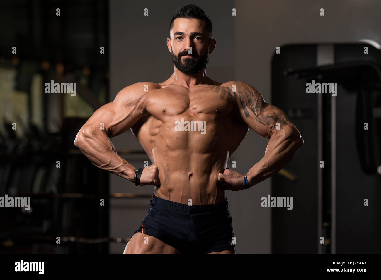 Portrait d'un jeune homme en bonne forme physique montrant son tatouage ...