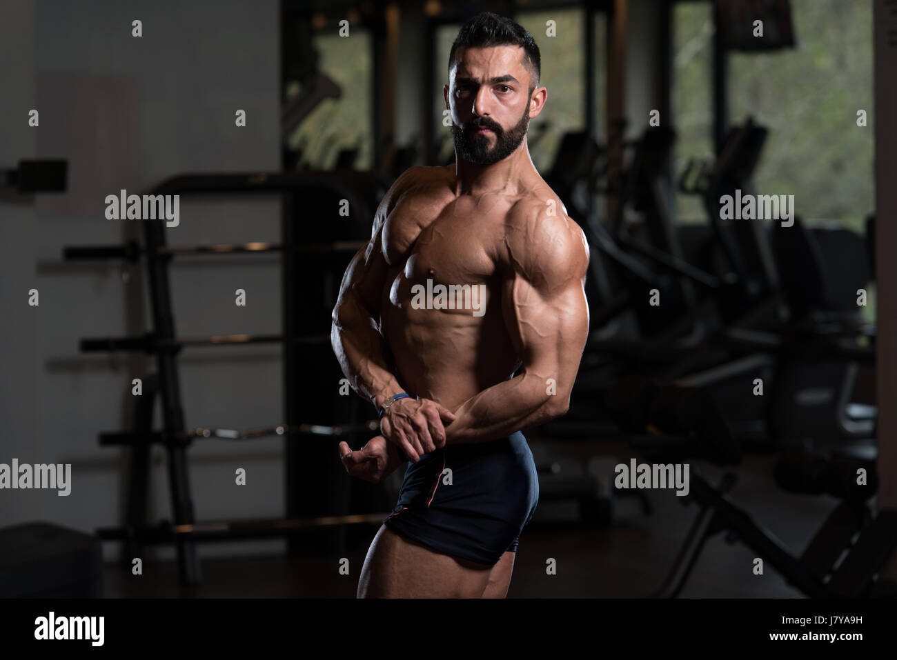 Portrait d'un jeune homme en bonne forme physique montrant son tatouage ...