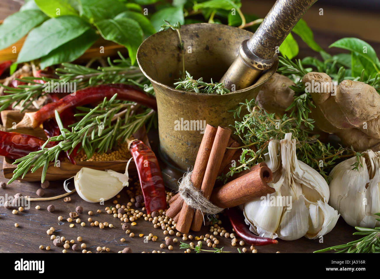Différentes herbes et épices sur une table en bois . Ancien mortier en ...