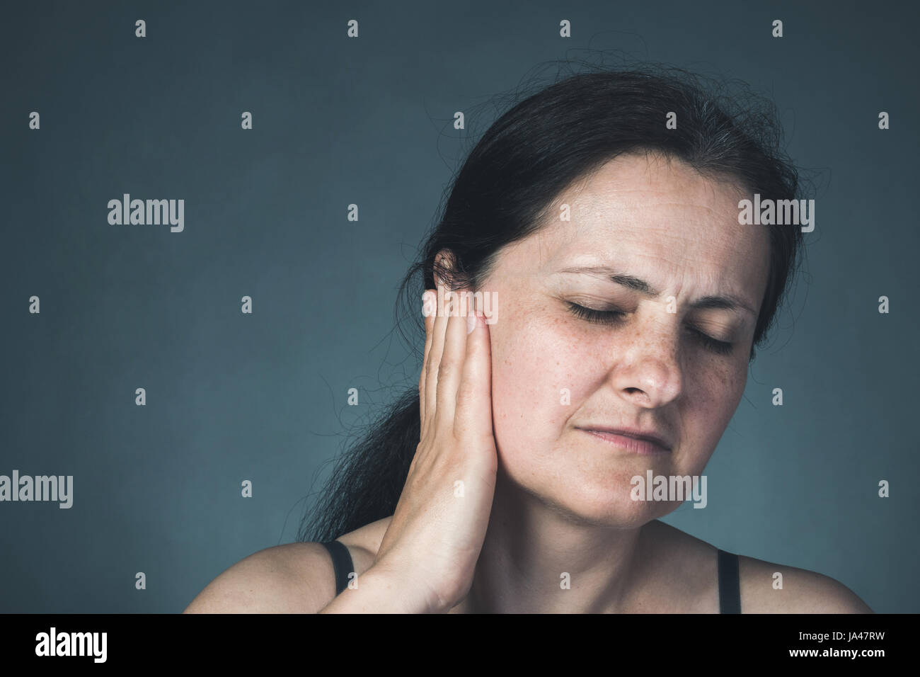 Une femme qui a mal aux oreilles Photo Stock - Alamy