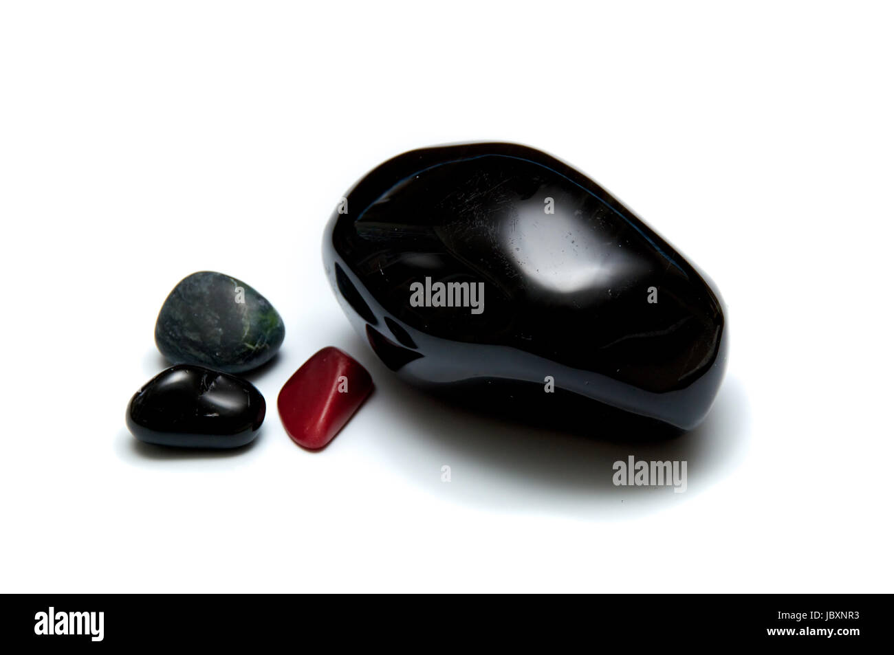 Une collection de quatre roches sombres lisse utilisé pour le massage ...