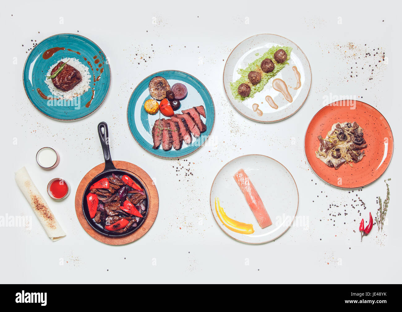 Les plaques avec des plats de viande et poisson sur un tableau blanc ...